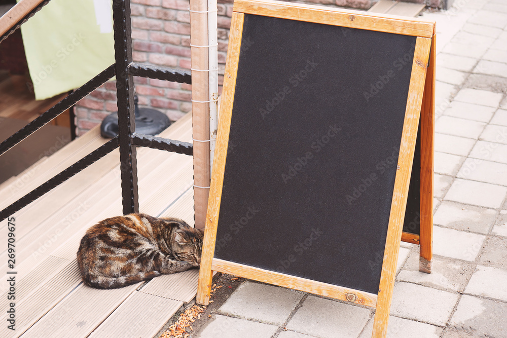 Blank menu stand and cat on cafe exterior background, mock up Stock ...