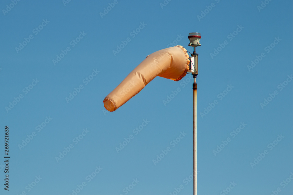 Windsock indicating wind direction and relative speed on blue sky ...
