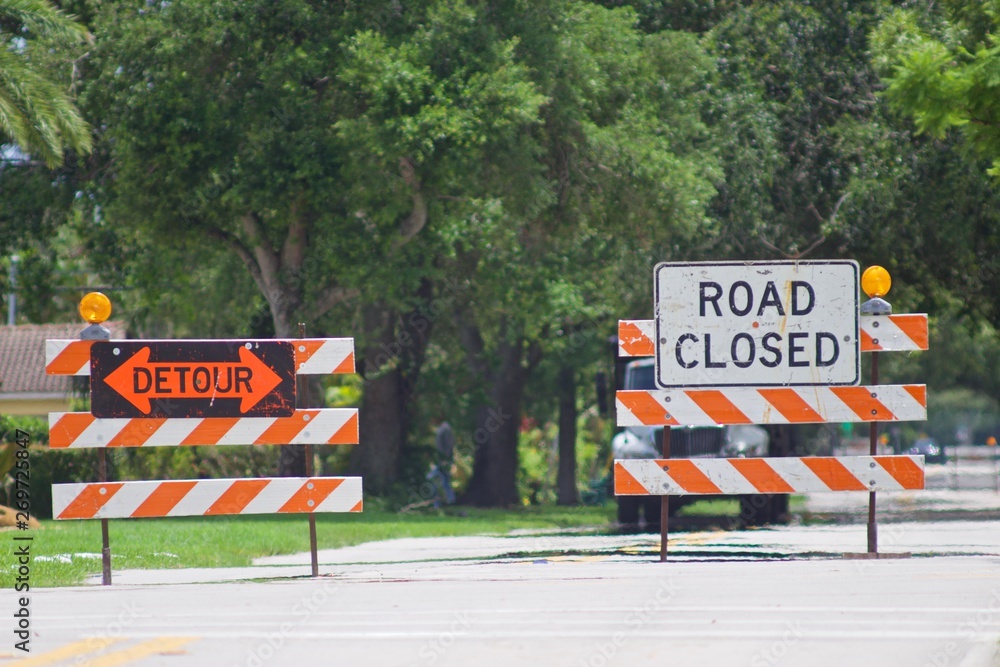Detour sign and Road Closed signs on orange and white striped road ...