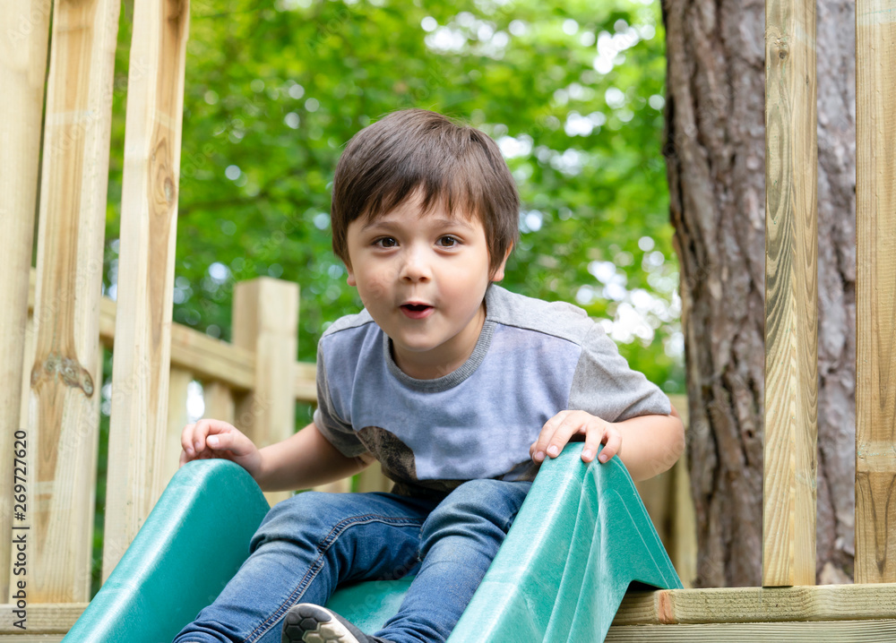 Cute little boy playing slide at the playground, Adorable kid sitting ...