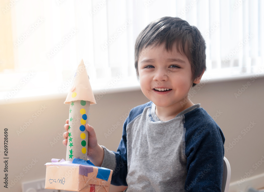 Cute little boy playing with spaceship, Happy child holding toy rocket ...