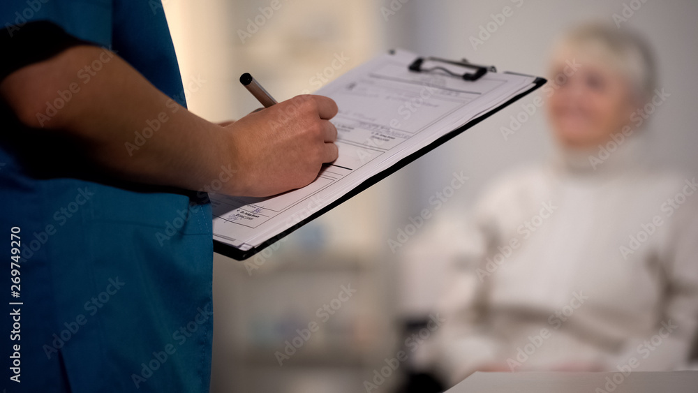 Doctor making notes in medical records, hospital examination, patient ...