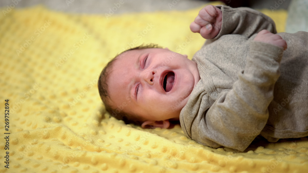 Newborn baby lying and crying suffering abdominal colic, emergence of ...