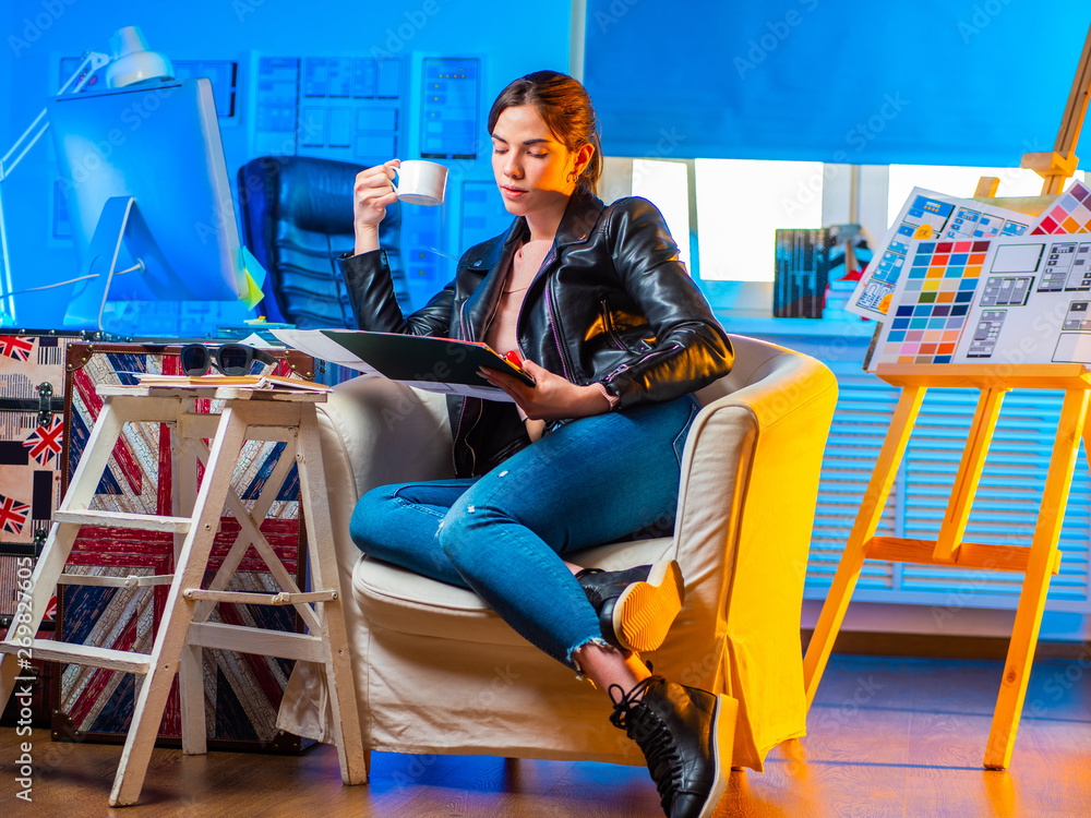 Supernumerary designer. Freelance girl designer looks at the drawn ...