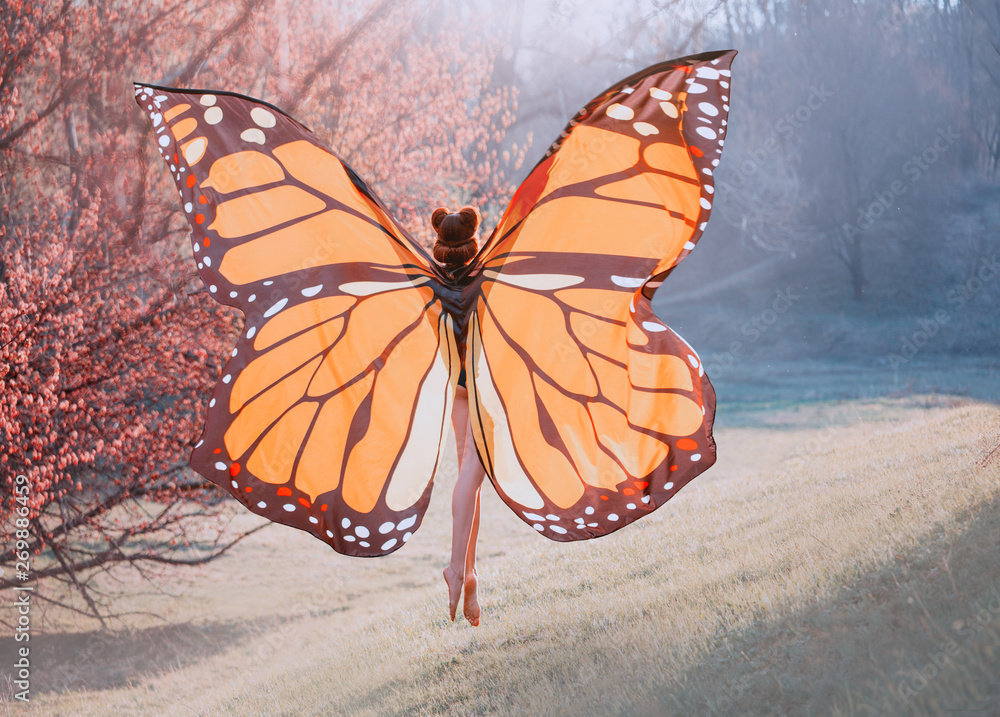 A monarch butterfly enjoys flying. A young woman with a perfect body ...