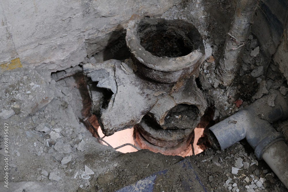 Garbage and dirt during sewage repair. Hole between the floors of an ...
