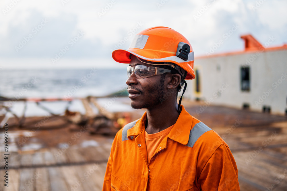 Tired Seaman AB or Bosun on deck of vessel or ship , wearing PPE ...