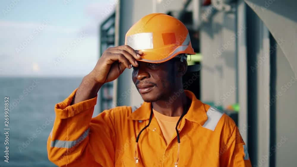 Tired Seaman AB or Bosun on deck of vessel or ship , wearing PPE ...