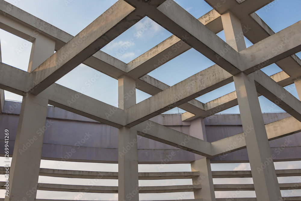 Looking up at the concrete pillars and beams at the top of modern high ...