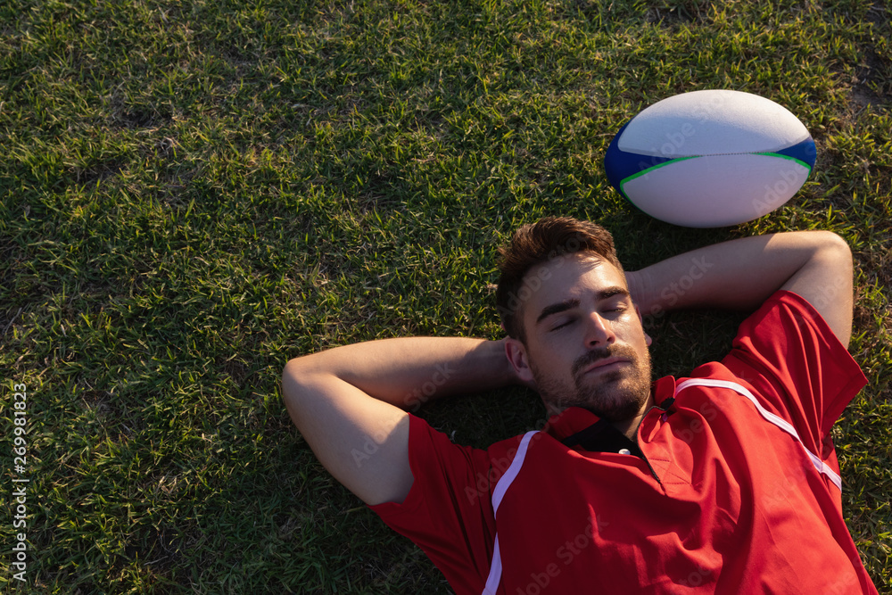 Upset male rugby player lying with rugby ball in the stadium Stock ...
