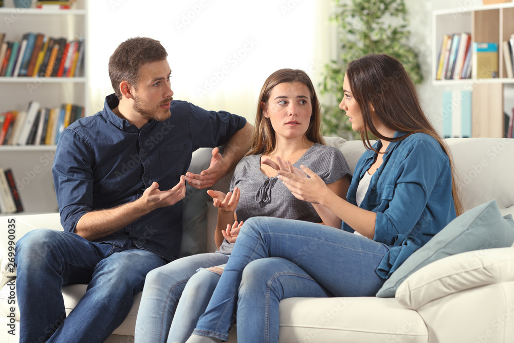 Three serious friends talking sitting on a couch at home Stock Photo ...