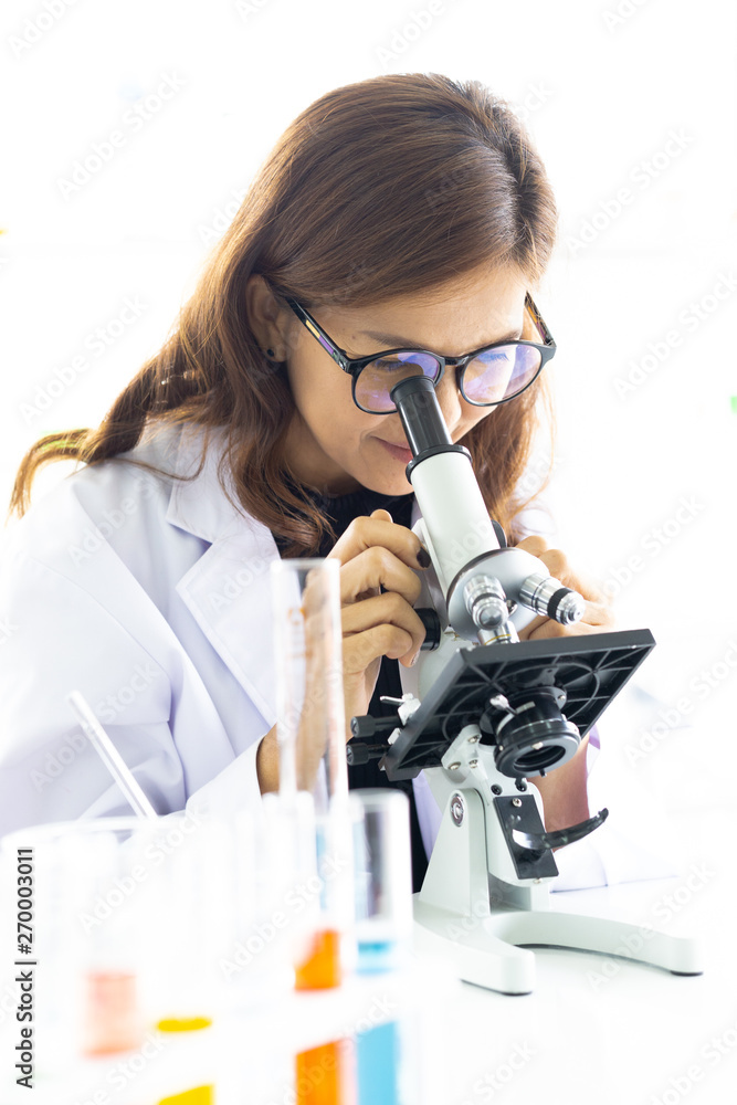 Asian female scientist wearing eyeglasses is researching using ...