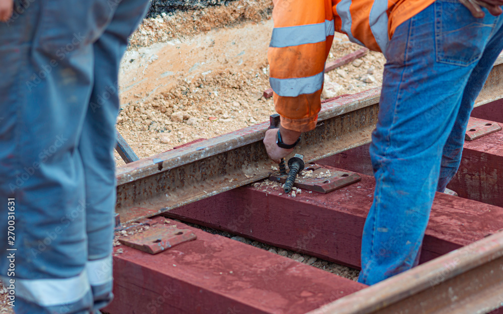 Railway workers bolting track rail. Detail worker with mechanical ...