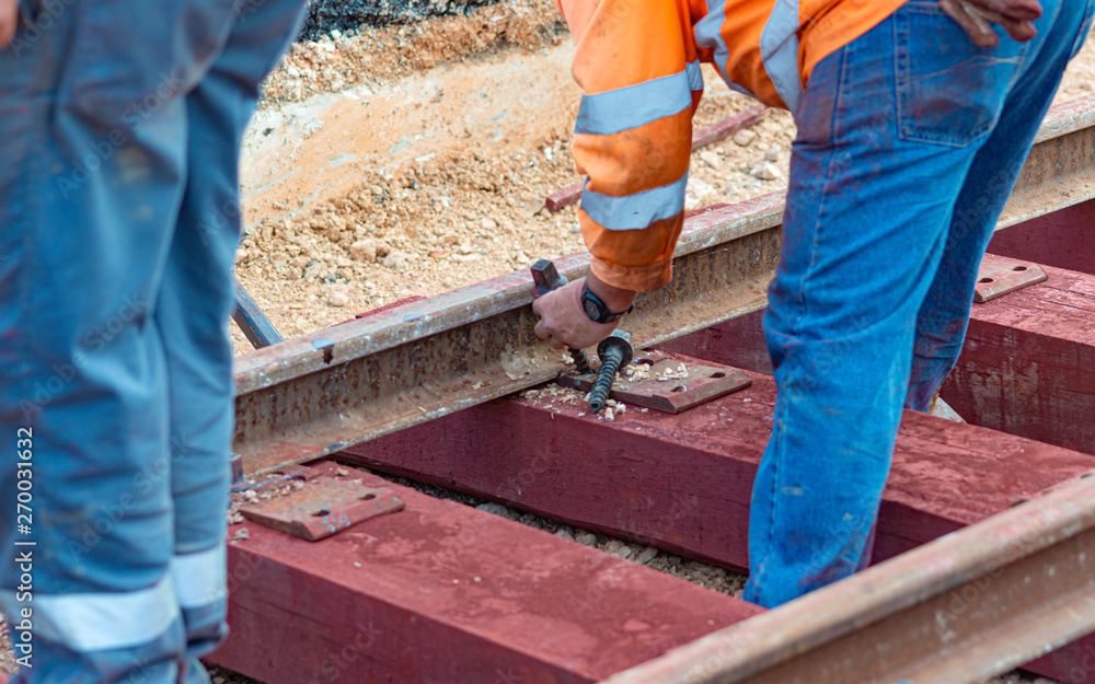 Railway workers bolting track rail. Detail worker with mechanical ...