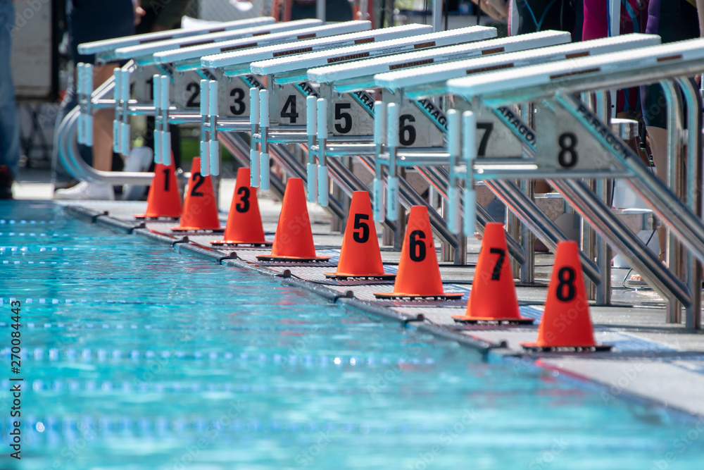 Starting blocks at the edge of a competition swimming pool. Sunny ...
