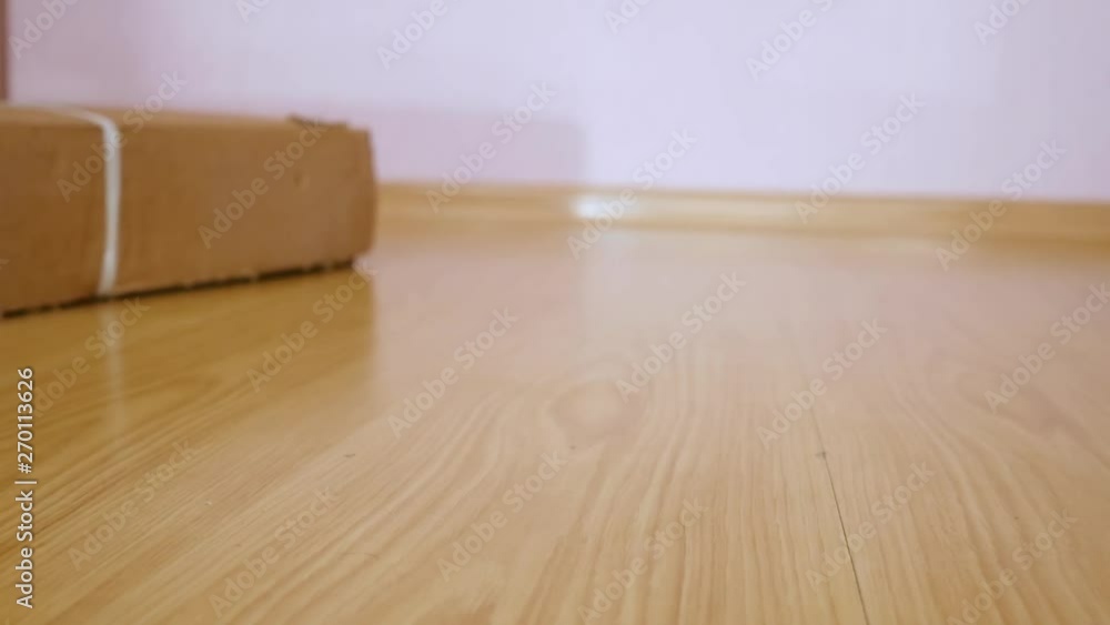 Wood floor. Closed cardboard box on the floor. Box for moving ...