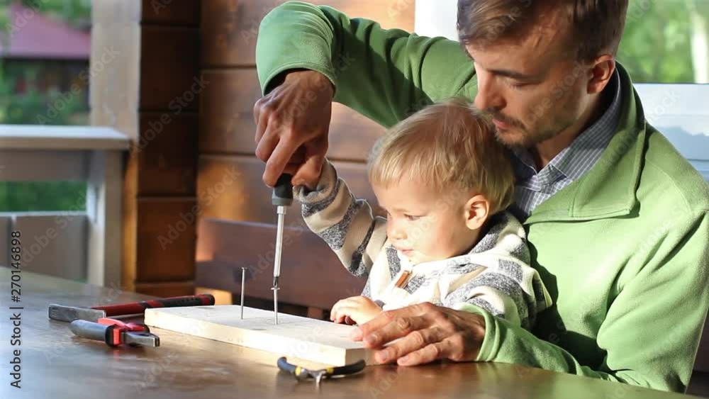 Father teaches his child to use construction tools - screw the screws ...