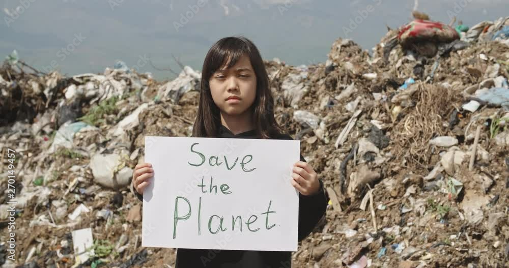Asian kid on dump site holding ecological slogans, little activist ...