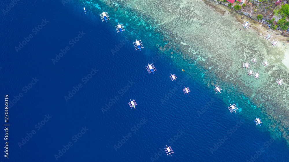 Aerial view of Filipino boats floating on top of clear blue waters ...