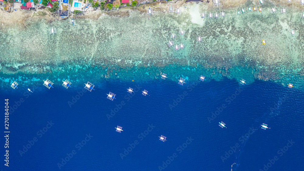 Aerial view of Filipino boats floating on top of clear blue waters ...