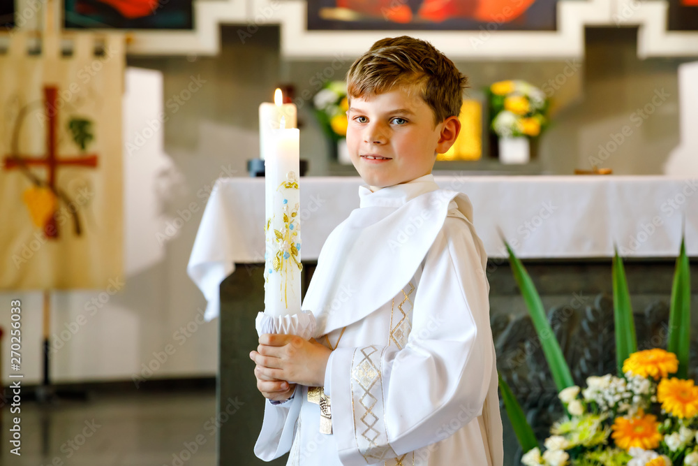 Little kid boy receiving his first holy communion. Happy child holding ...