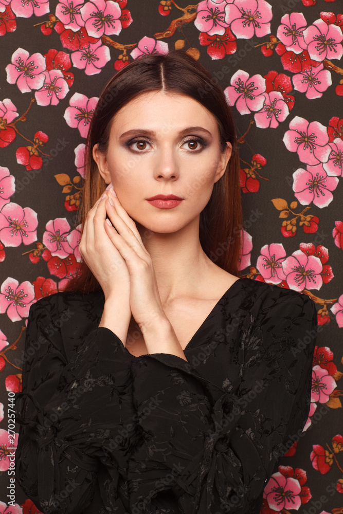 Portrait of a beautiful woman in a black dress. Background from a ...