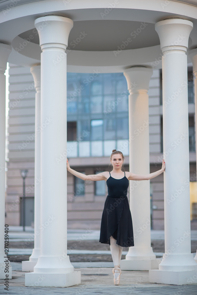 Ballerina in a black dress is a beautiful pose. A beautiful young woman ...