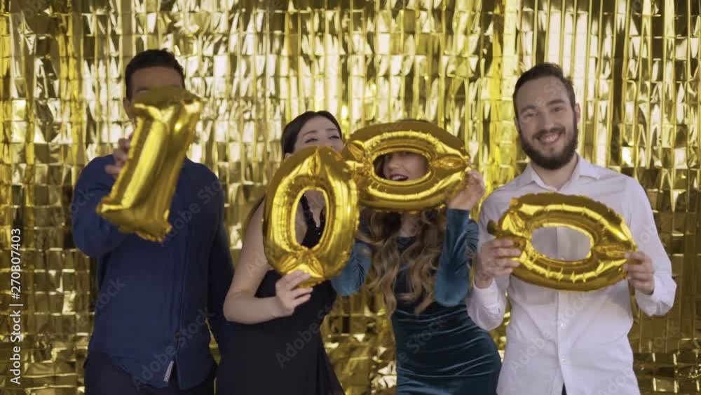 The number 100 of foil. 4 happy cheerful people at a party with ...