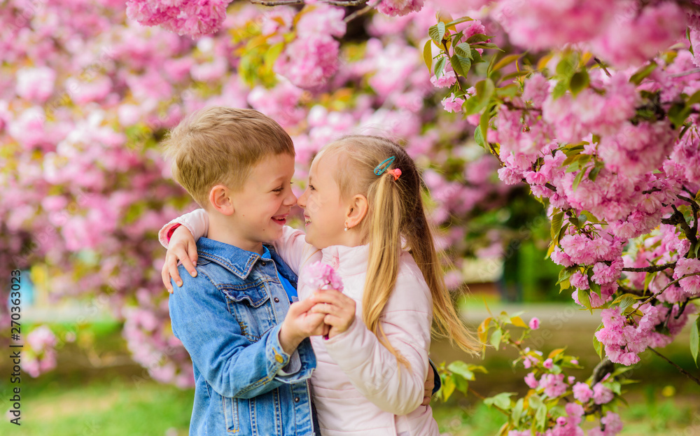 Romantic babies. Tender love feelings. Couple kids on flowers of sakura ...