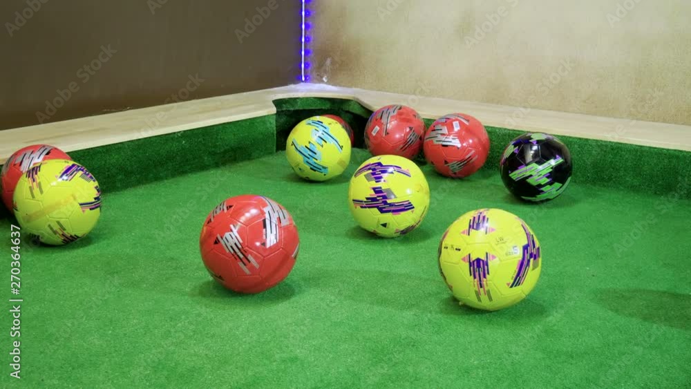 Two men playing billiards, hitting balls with legs, kicking it into ...