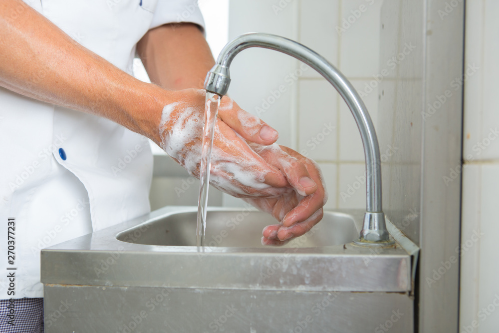 chef washing his hands in commercial kitchen Photos | Adobe Stock