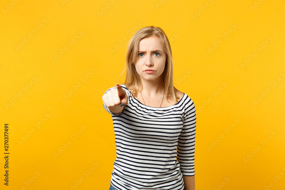 Portrait of strict young woman in striped clothes pointing index finger ...