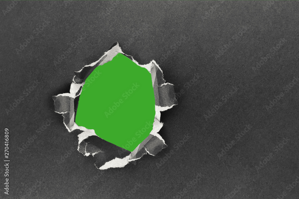 Torn hole in the sheet of paper on a green background. Rip and torn ...