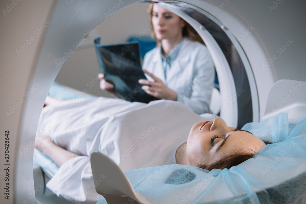 selective focus of radiologist holding x-ray diagnosis while patient ...