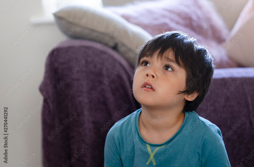 Cute little boy sitting on the floor watching TV in playroom, Portrait ...