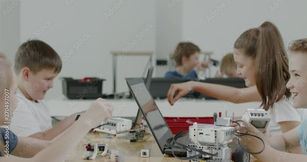 Curious kids working on a functional programable robot during robotics ...
