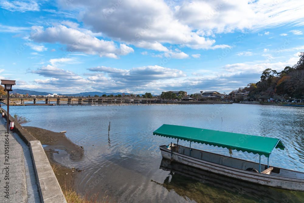 Boat at Hozu-gawa River and Togetsu-kyo bridge with colourful forest ...