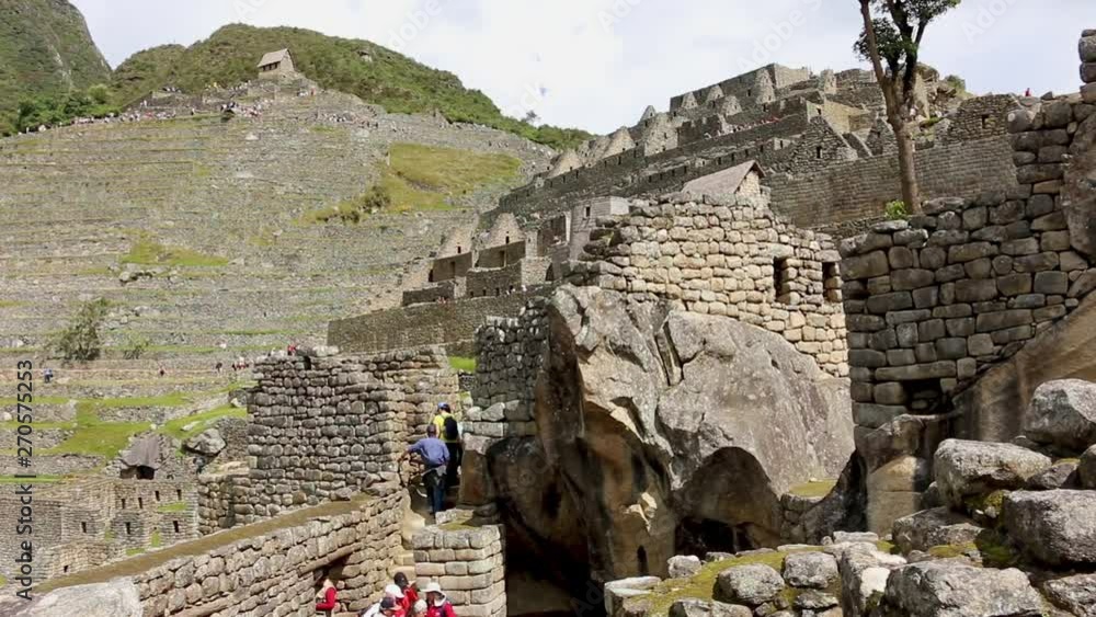 Medium low-angle still shot of Machu Picchu terraces, and a large ...