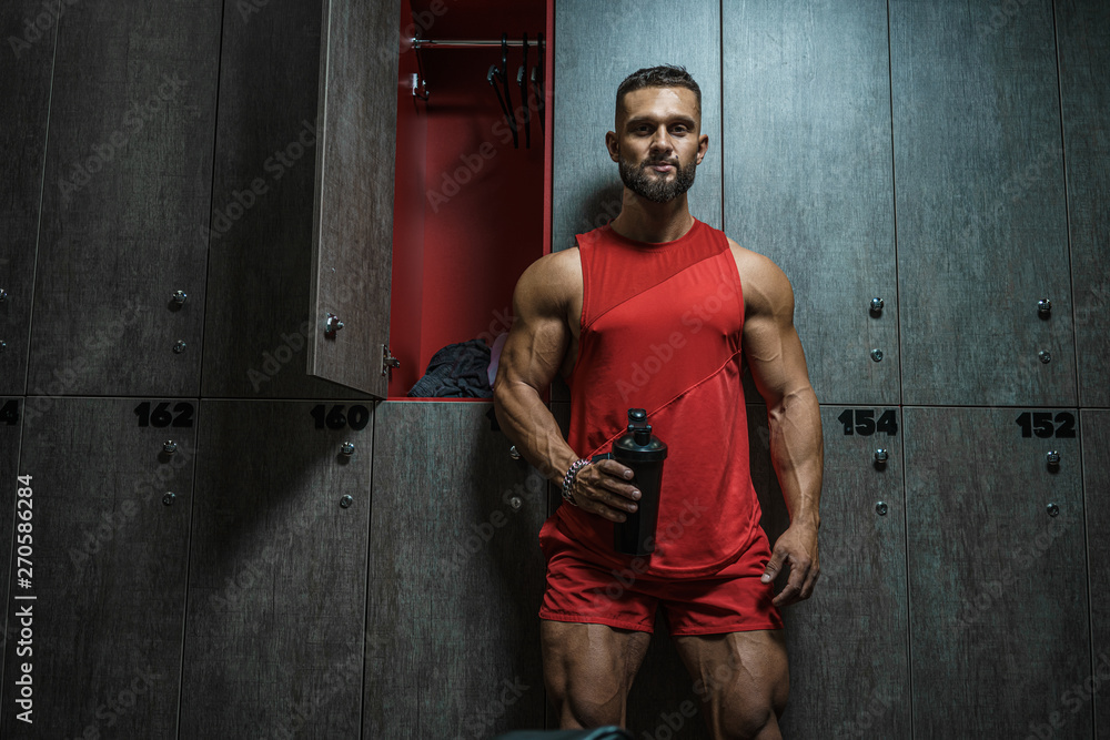 handsome muscular athletic man with a towel in the locker room after ...