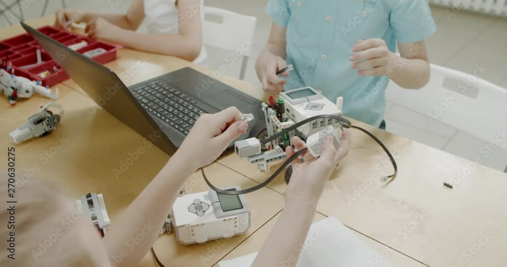 Curious kids working on a functional programable robot during robotics ...