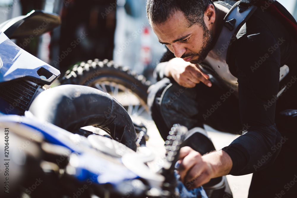 Motocross driver looks at broken parts of his bike Stock Photo | Adobe ...