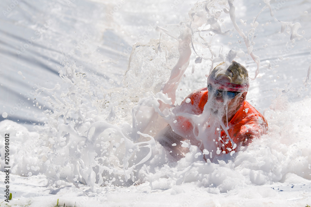 Sliding down a foam filled water slide. Foam and spray everywhere. Face ...