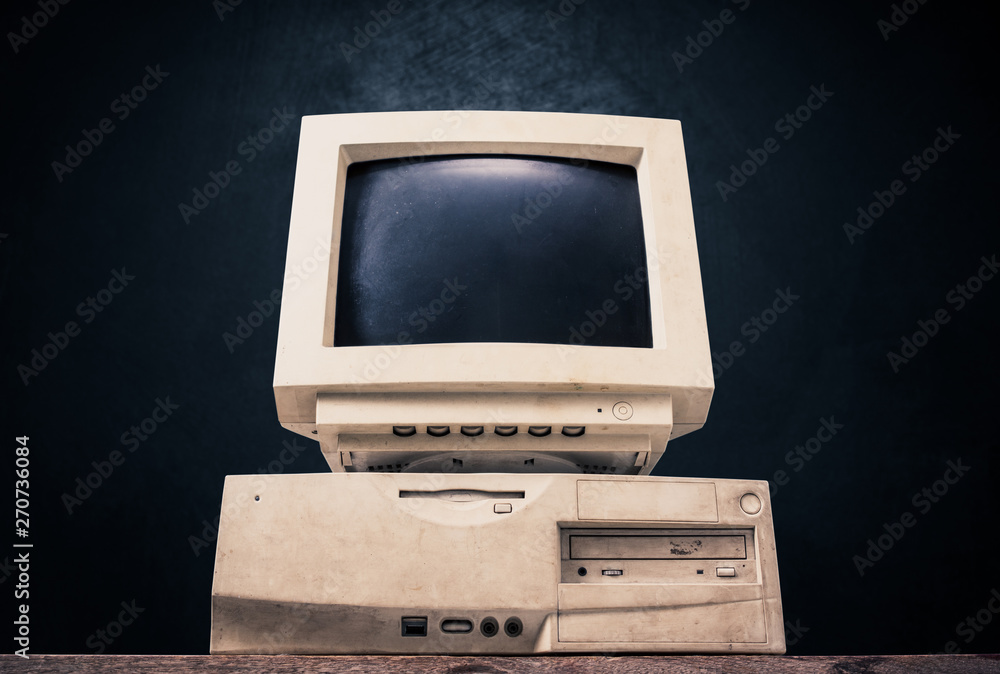 Front side of old and obsolete computer on old wood table with dark ...
