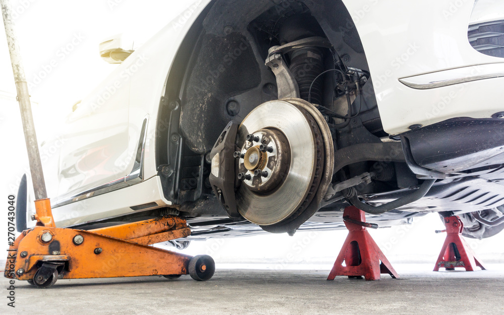 Car without wheel on car jack with car stands for safety in repair shop ...