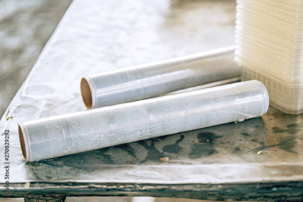Food wrap in a roll on the table in a cafe. Disposable plastic ...