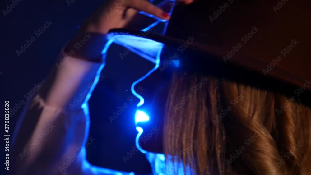 Sexy young girl model at the studio. Black background, blue spotlight ...