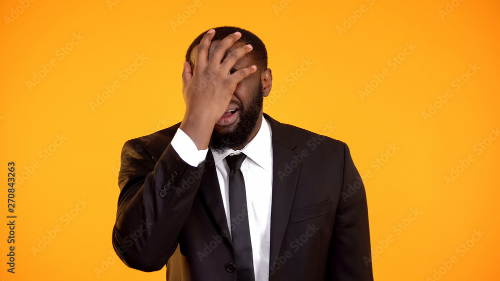 Deeply disappointed and shocked african-american male in suit making ...