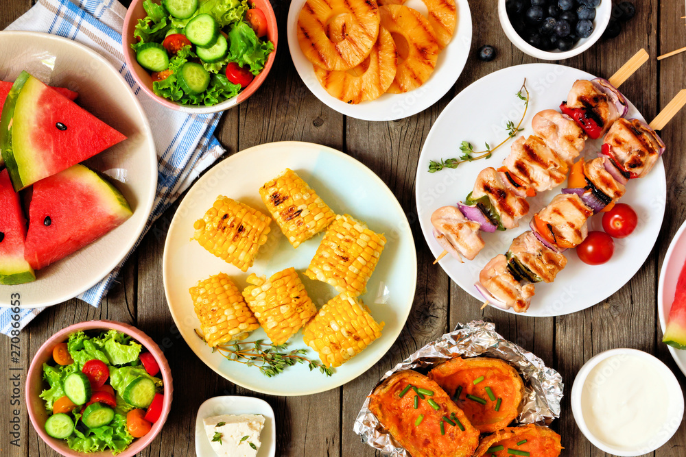 Summer BBQ or picnic food concept. Selection of fruits, salad, grilled ...