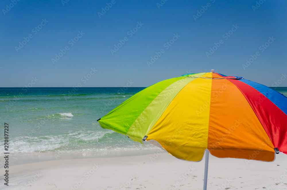 Colorful umbrella at ocean beach shoreline. Scenic tourist travel ...
