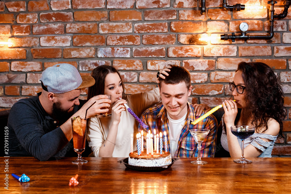 young friends celebrate the birthday of a guy in a bar. youth with ...